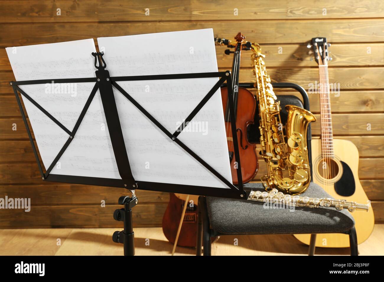 Musical instruments on a chair and note holder against wooden ...
