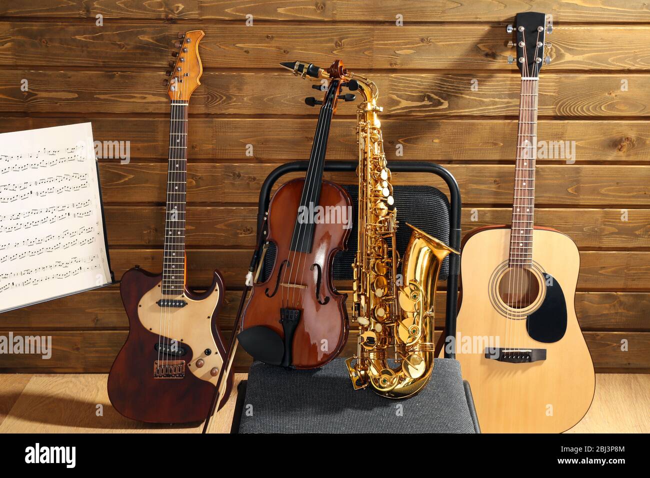 Musical instruments on a chair and note holder against wooden ...