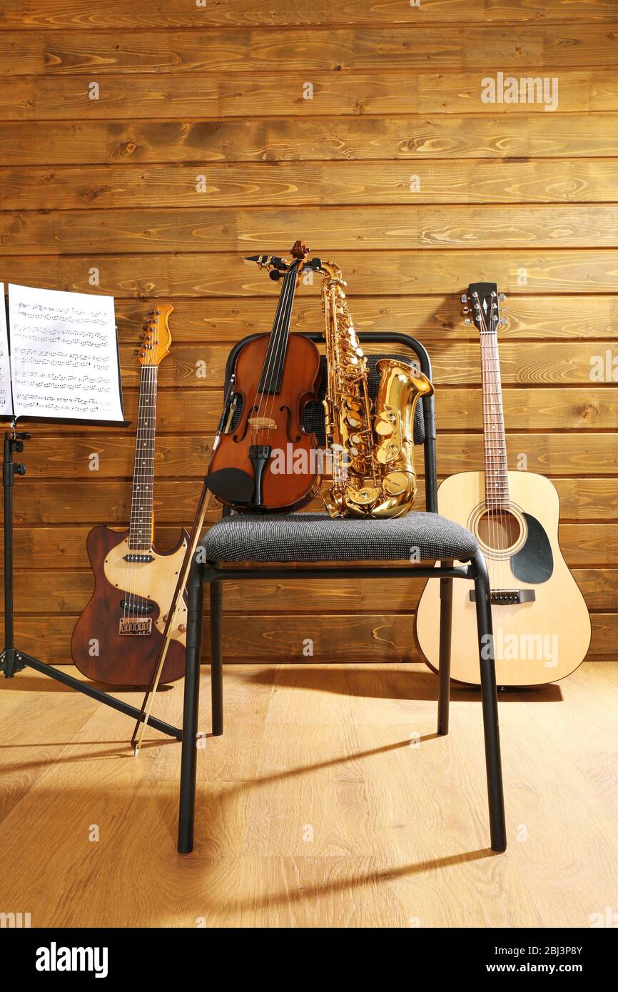 Musical instruments on a chair and note holder against wooden ...