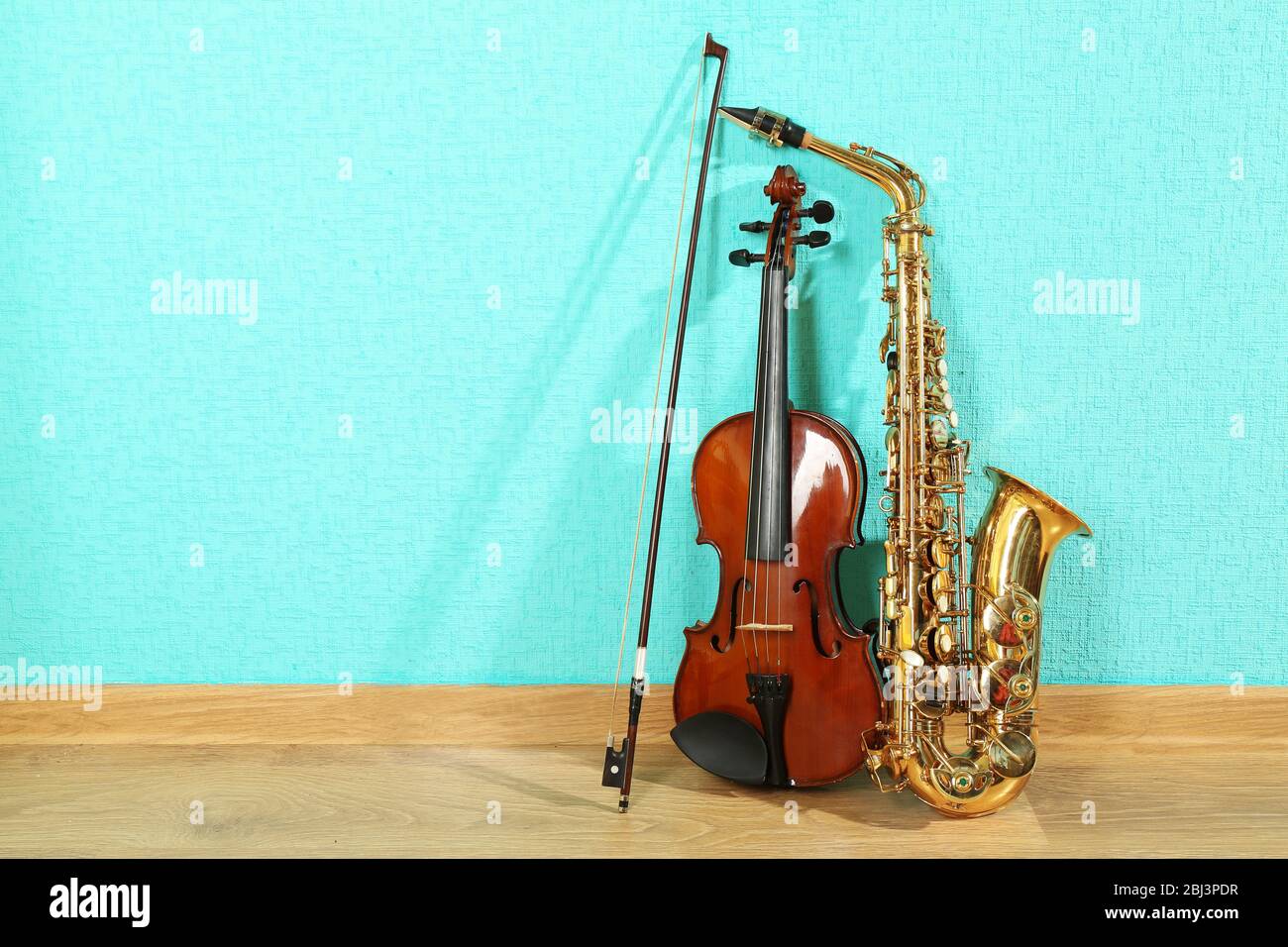 Violin and saxophone on the floor against blue background Stock Photo ...
