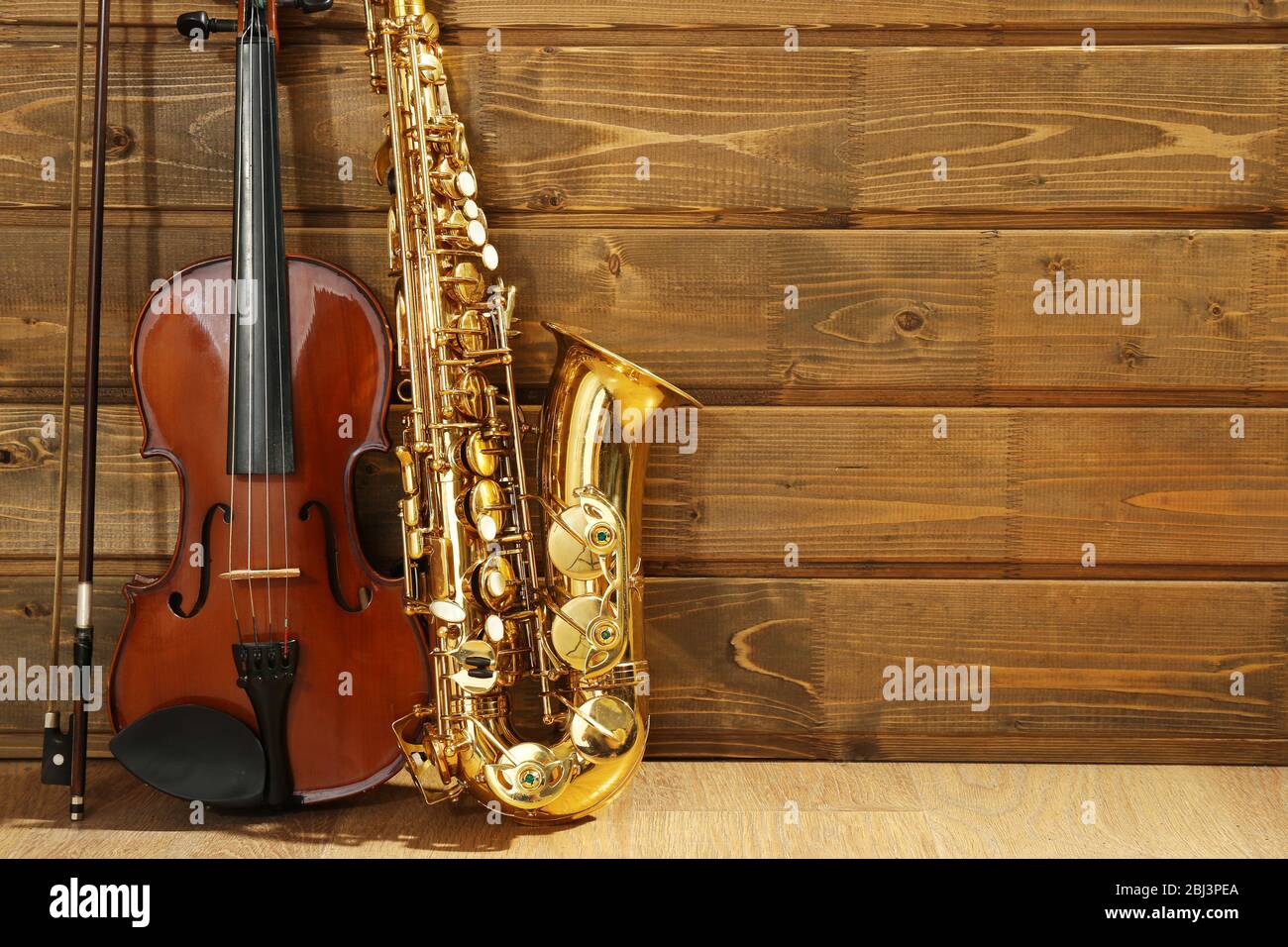 Violin and saxophone on wooden background Stock Photo - Alamy