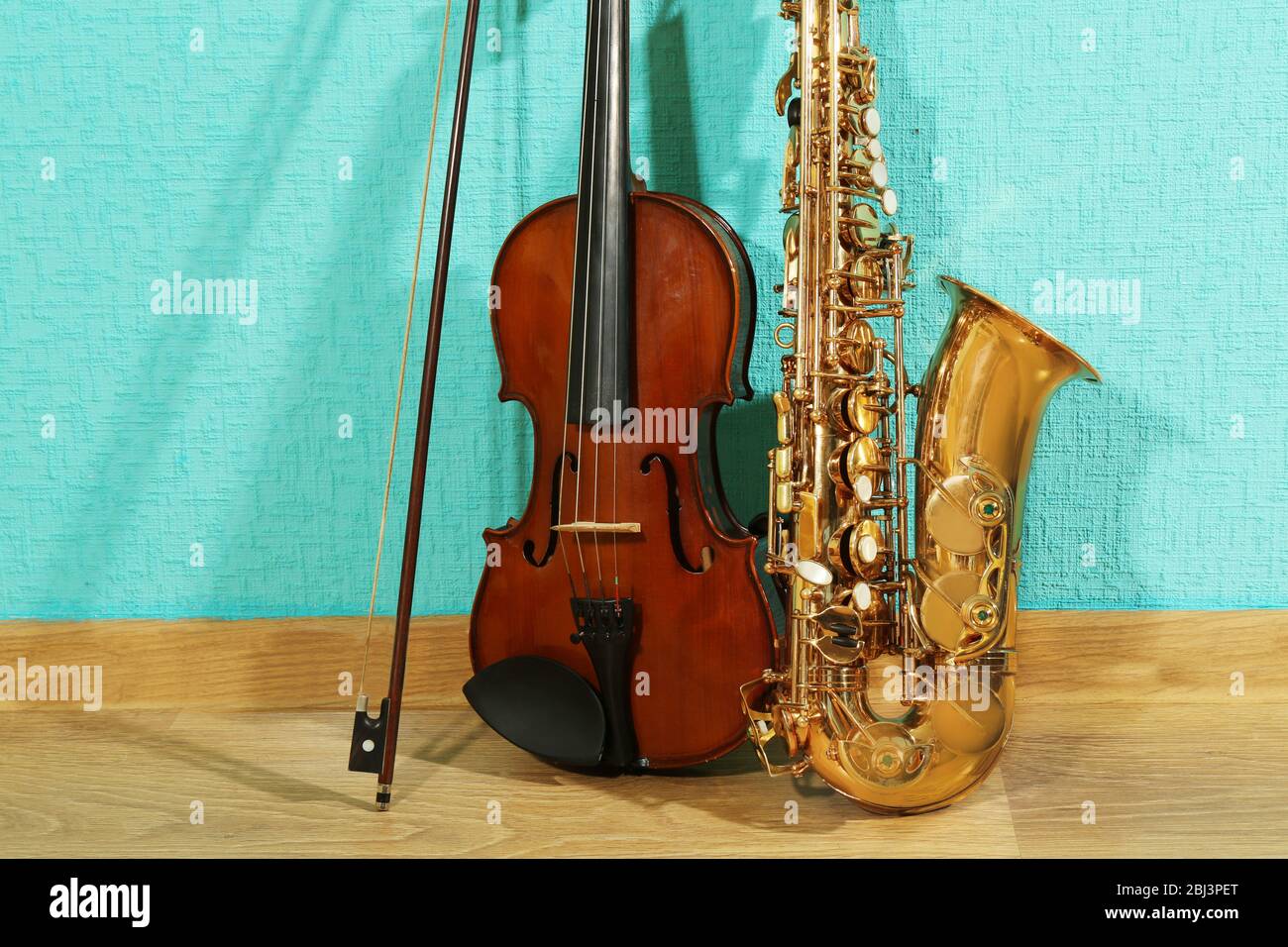 Violin and saxophone on the floor against blue background Stock Photo ...