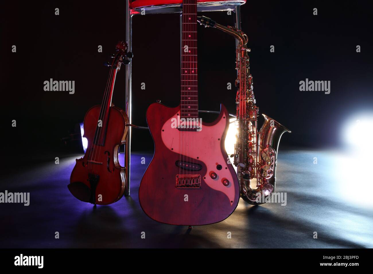 Beautiful golden saxophone and guitar near bar stool on a scene Stock ...