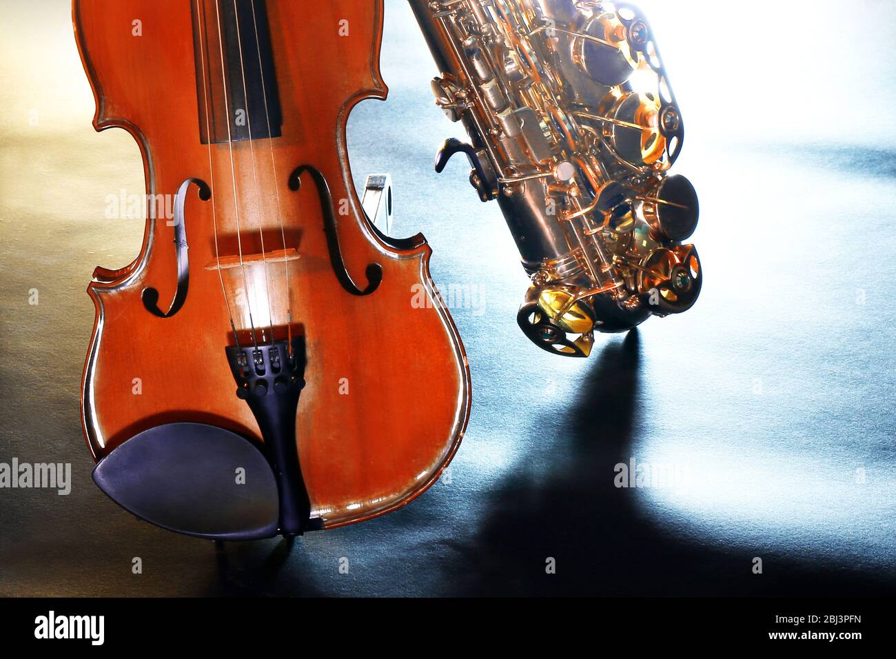 Beautiful golden saxophone with violin on a scene Stock Photo - Alamy