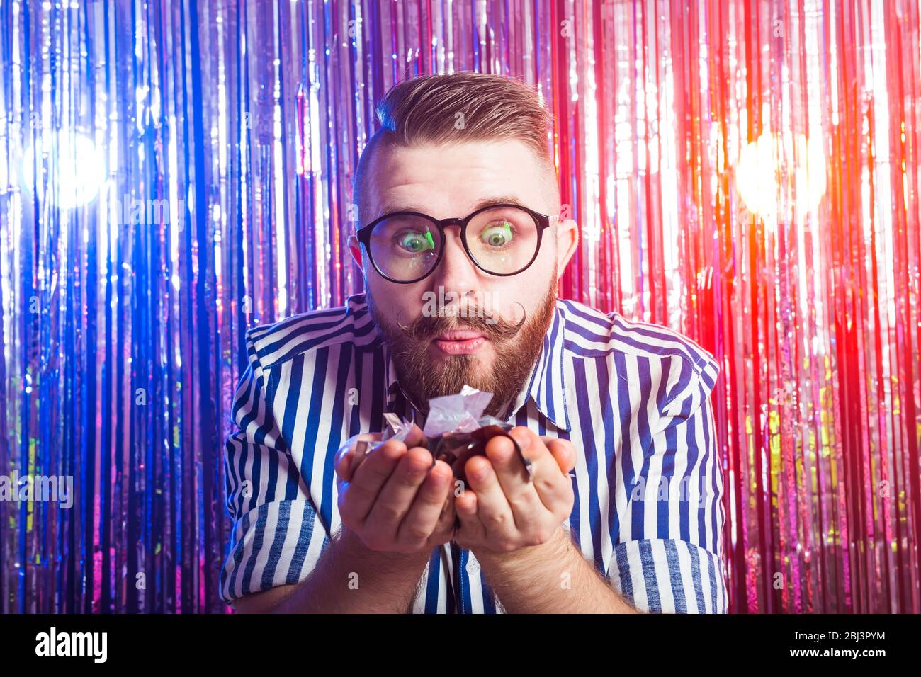 Party, carnival, holidays and fun concept - Fancy man blowing confetti ...