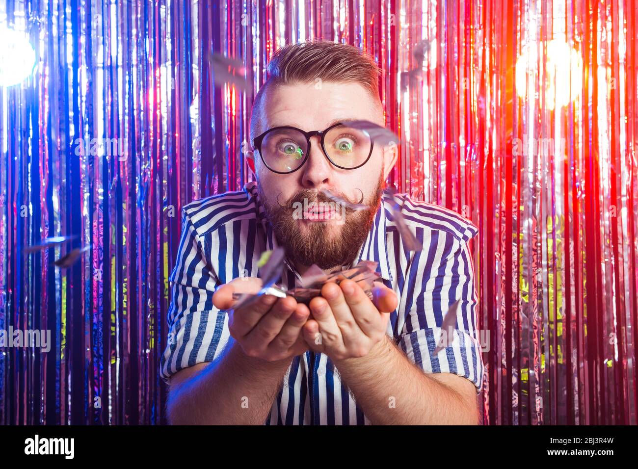 Party, carnival, holidays and fun concept - Fancy man blowing confetti ...