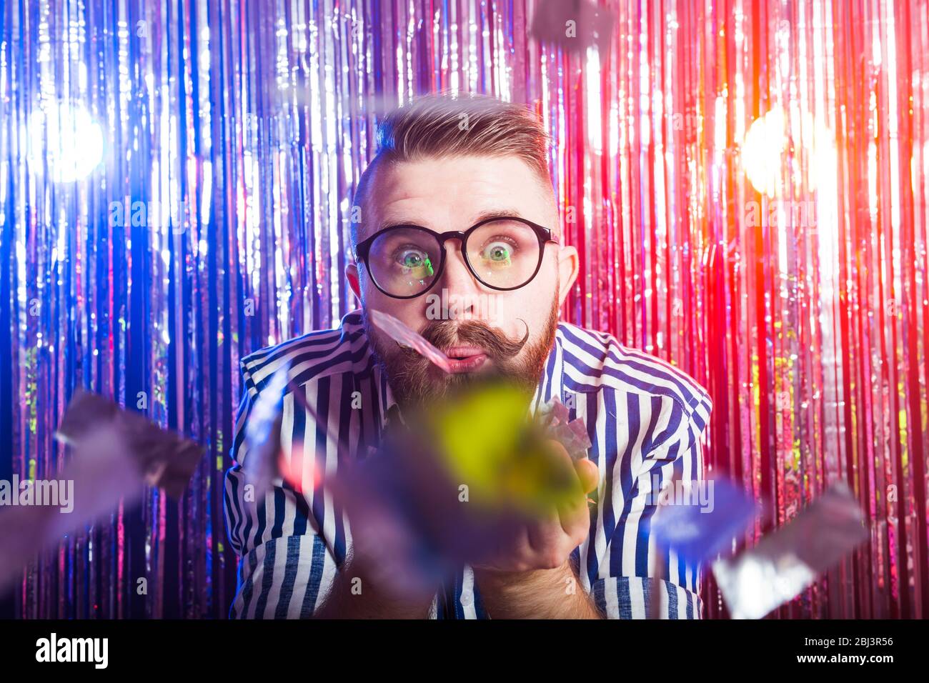 Party, carnival, holidays and fun concept - Fancy man blowing confetti ...