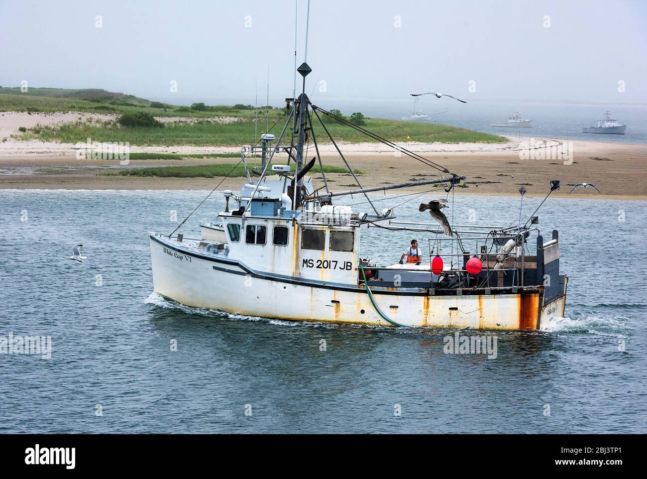 Commercial fishing boat enters Chatham harbour at Cape Cod in ...