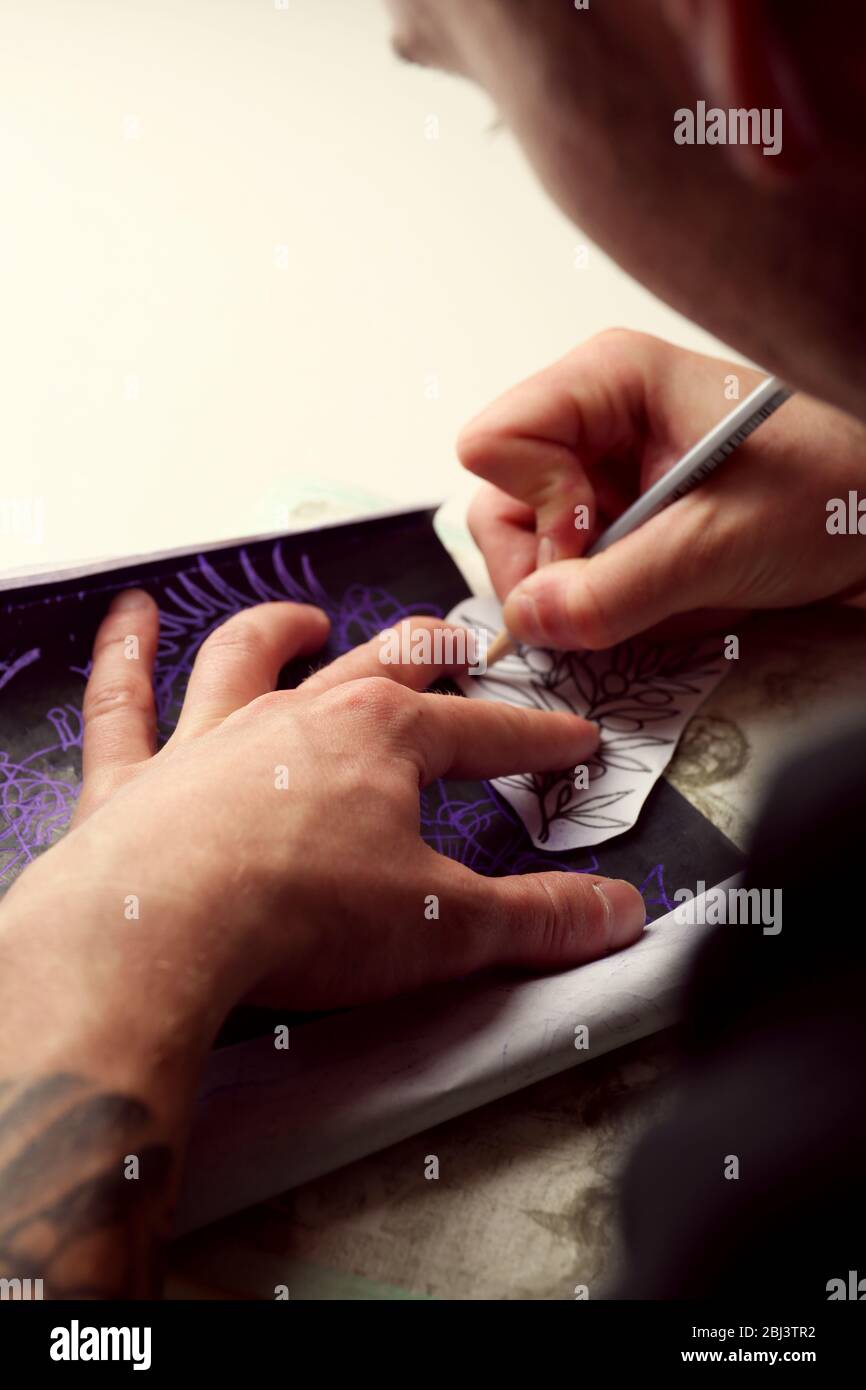 Professional tattoo artist drawing sketch Stock Photo - Alamy