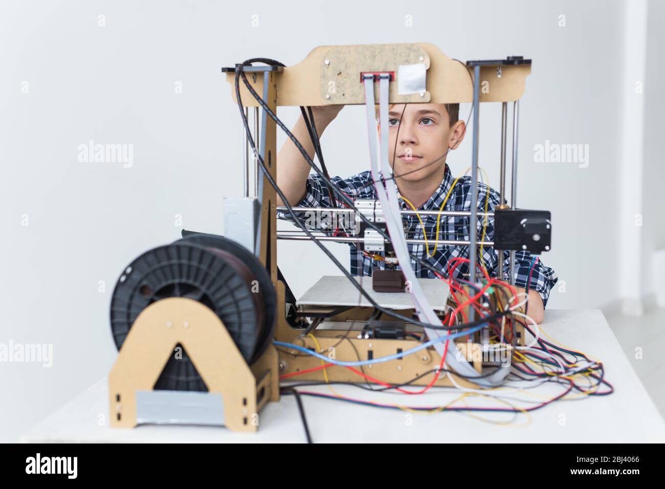Education, children, technology concept - teen boy is printing on 3d ...