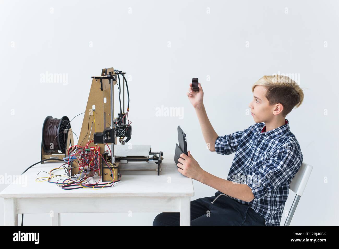 Education, children, technology concept - teen boy is printing on 3d ...