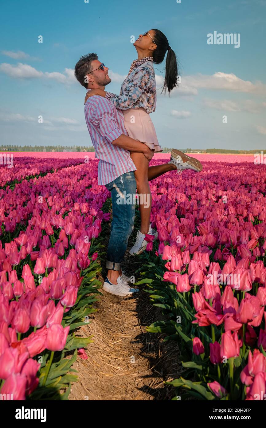 couple men and woman in flower field in the Netherlands during Spring ...
