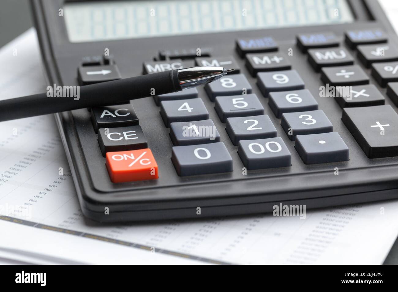 office table calculator with pen. Close up Stock Photo - Alamy