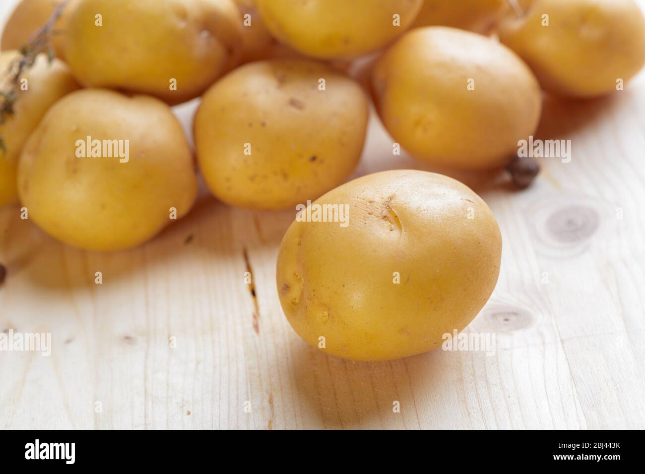 Fresh potatoes on the wood background. Close up Stock Photo - Alamy