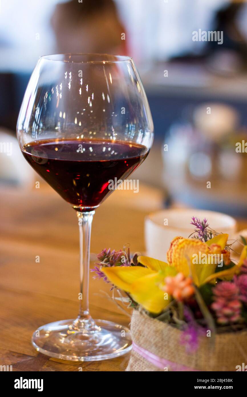 A glass of red wine on a wooden table Stock Photo - Alamy