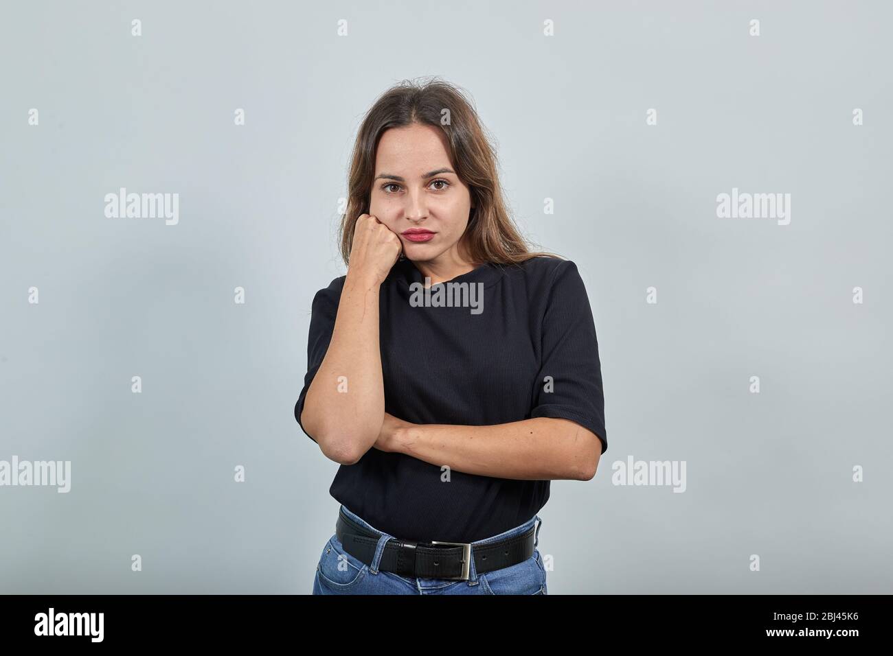 confused girl leans head on fist and looks forward Stock Photo - Alamy