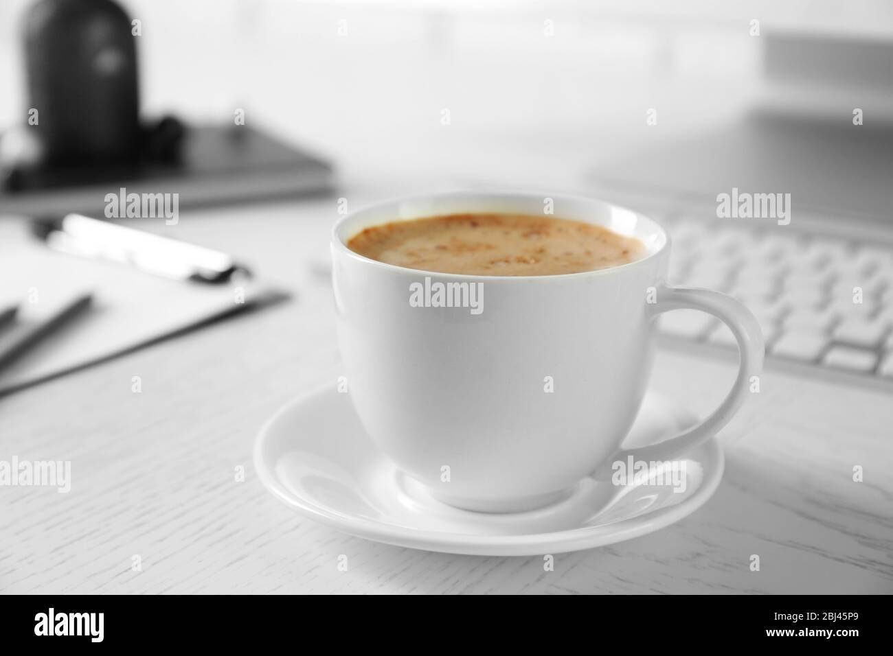 Cup of coffee on workplace background Stock Photo - Alamy