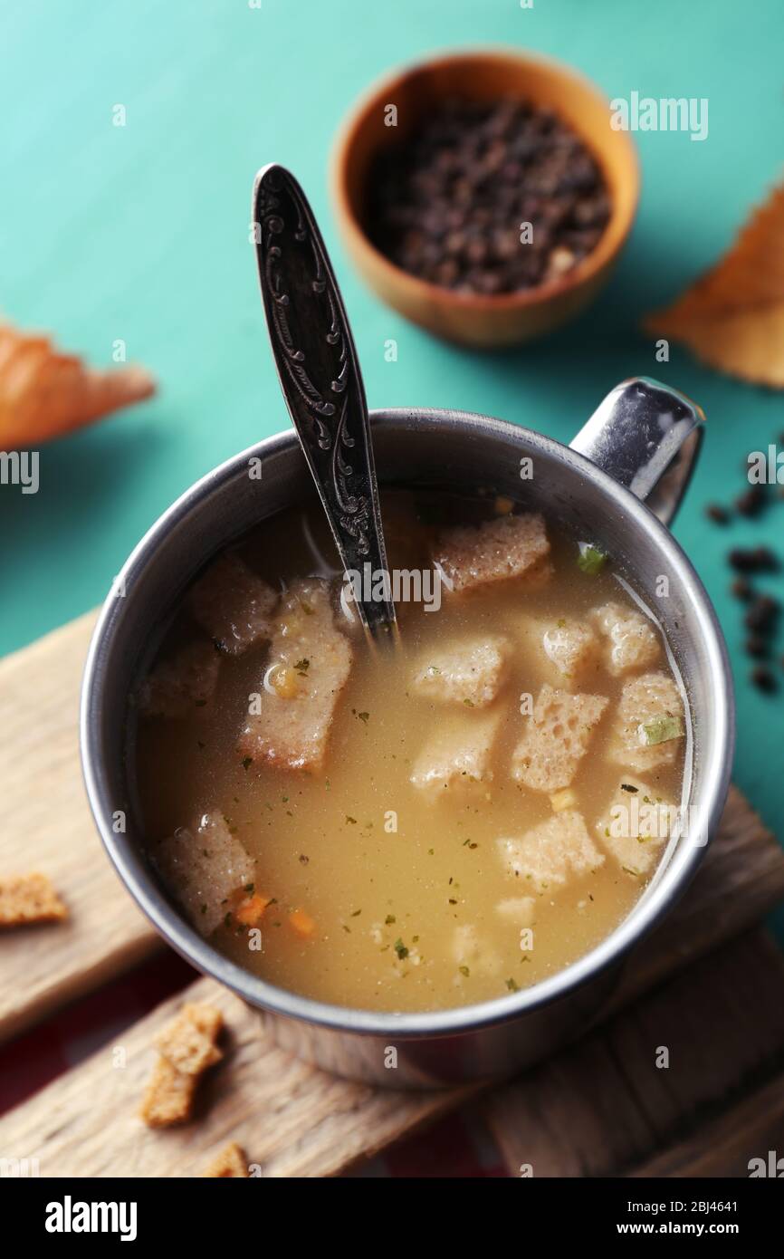 Mug of soup on wooden mat Stock Photo - Alamy