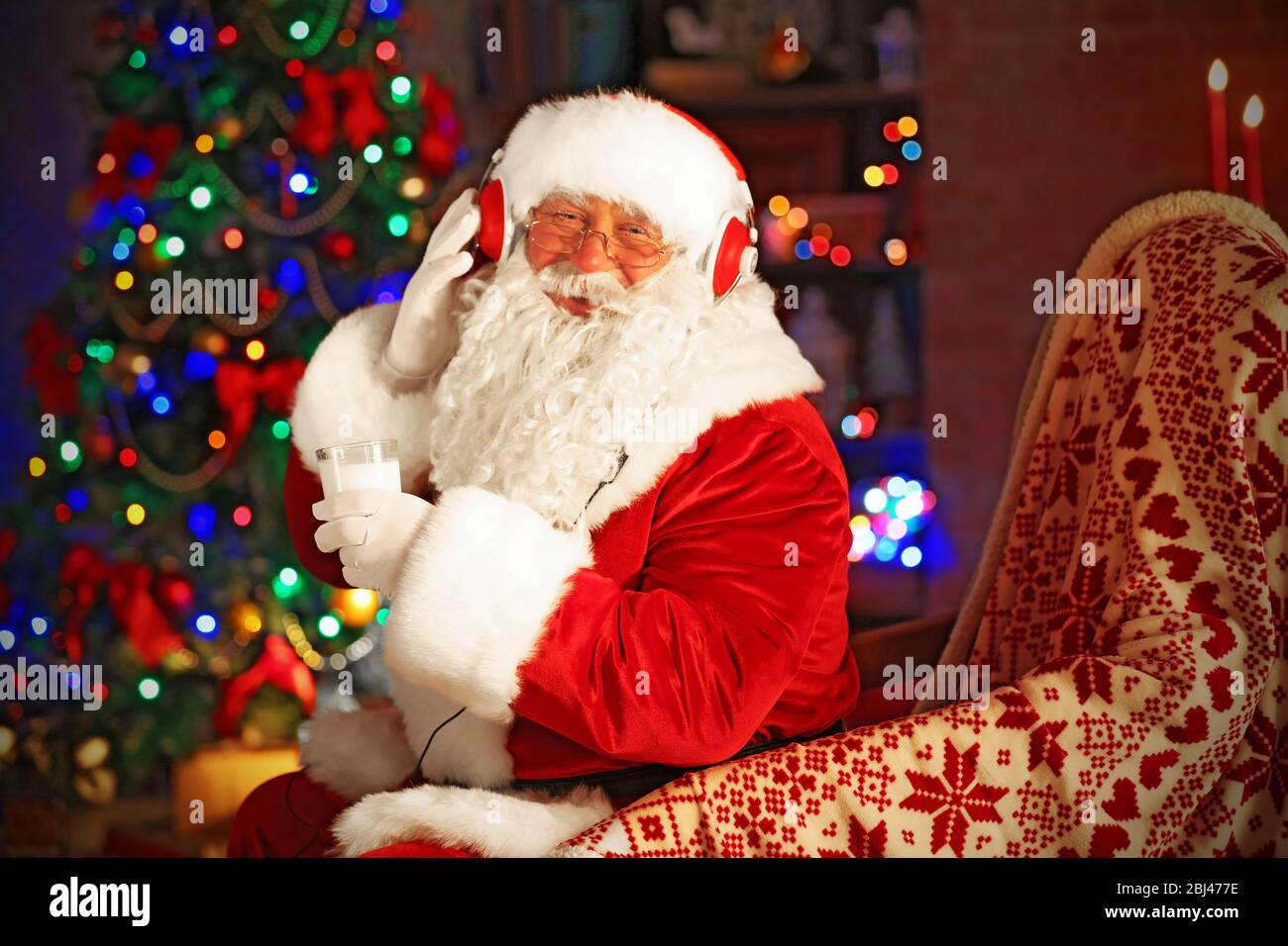 Santa Claus sitting with headphones sitting in comfortable rocking ...