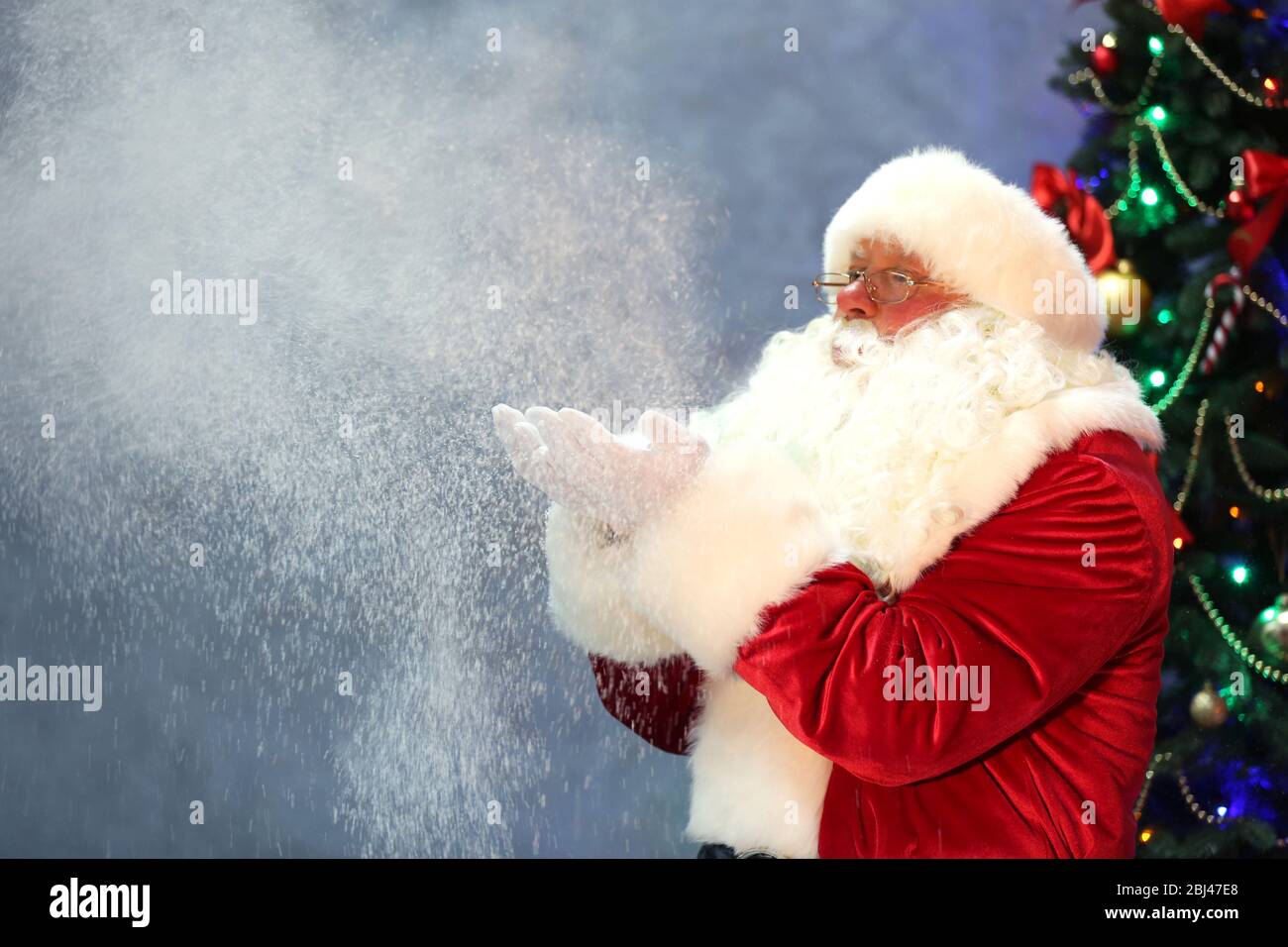 Santa Claus blowing snow on gray background Stock Photo - Alamy