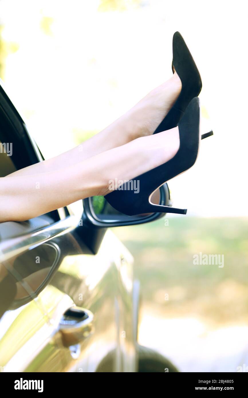 Woman's legs out of the car window Stock Photo - Alamy