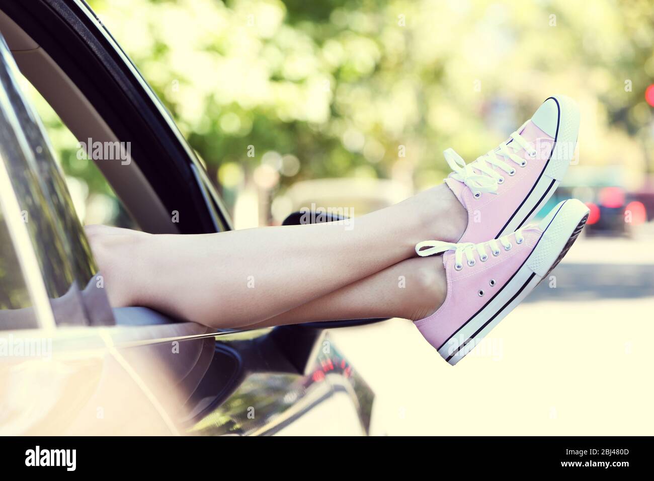 Woman's legs out of the car window Stock Photo - Alamy