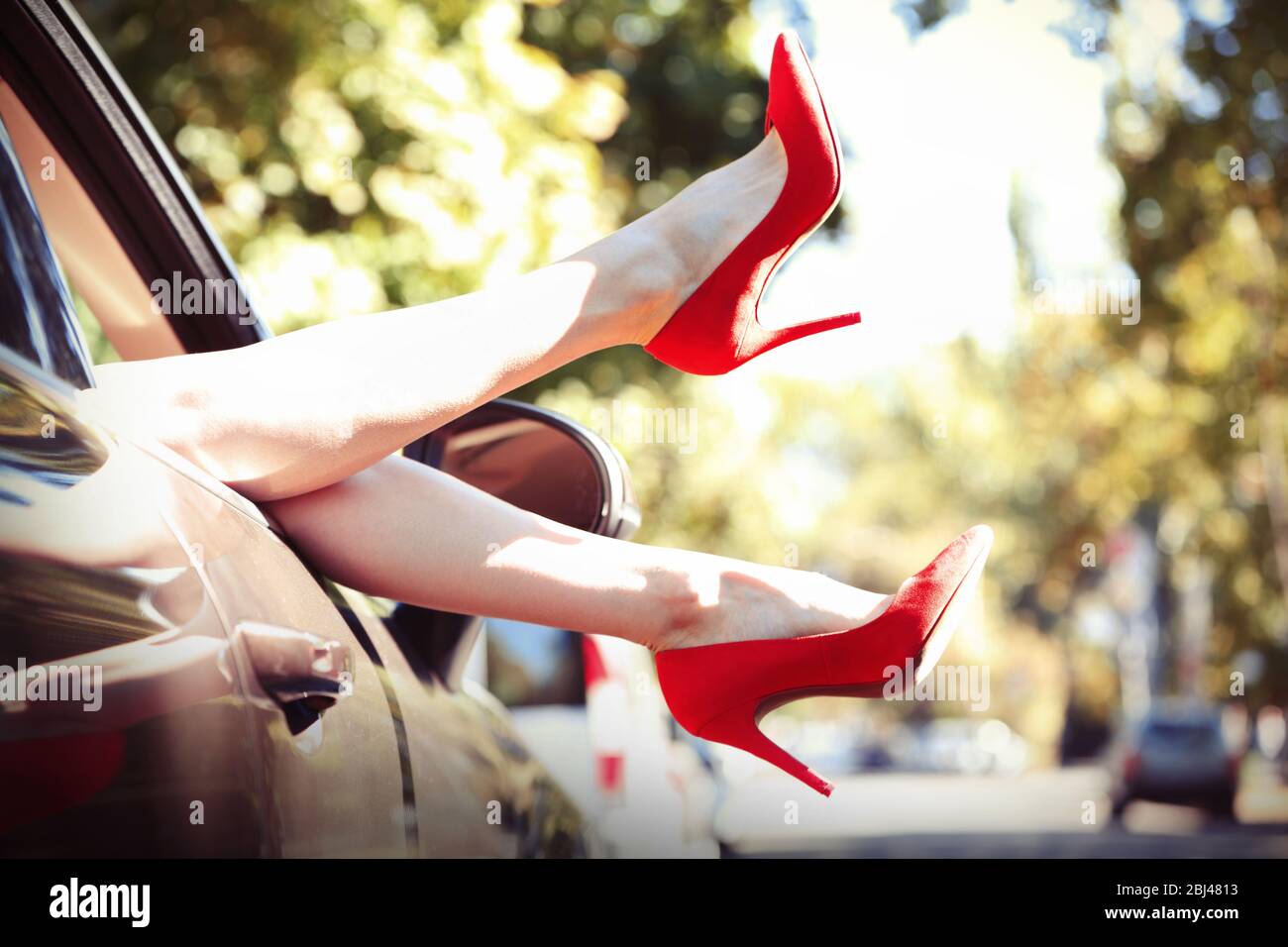 Woman's legs out of the car window Stock Photo - Alamy