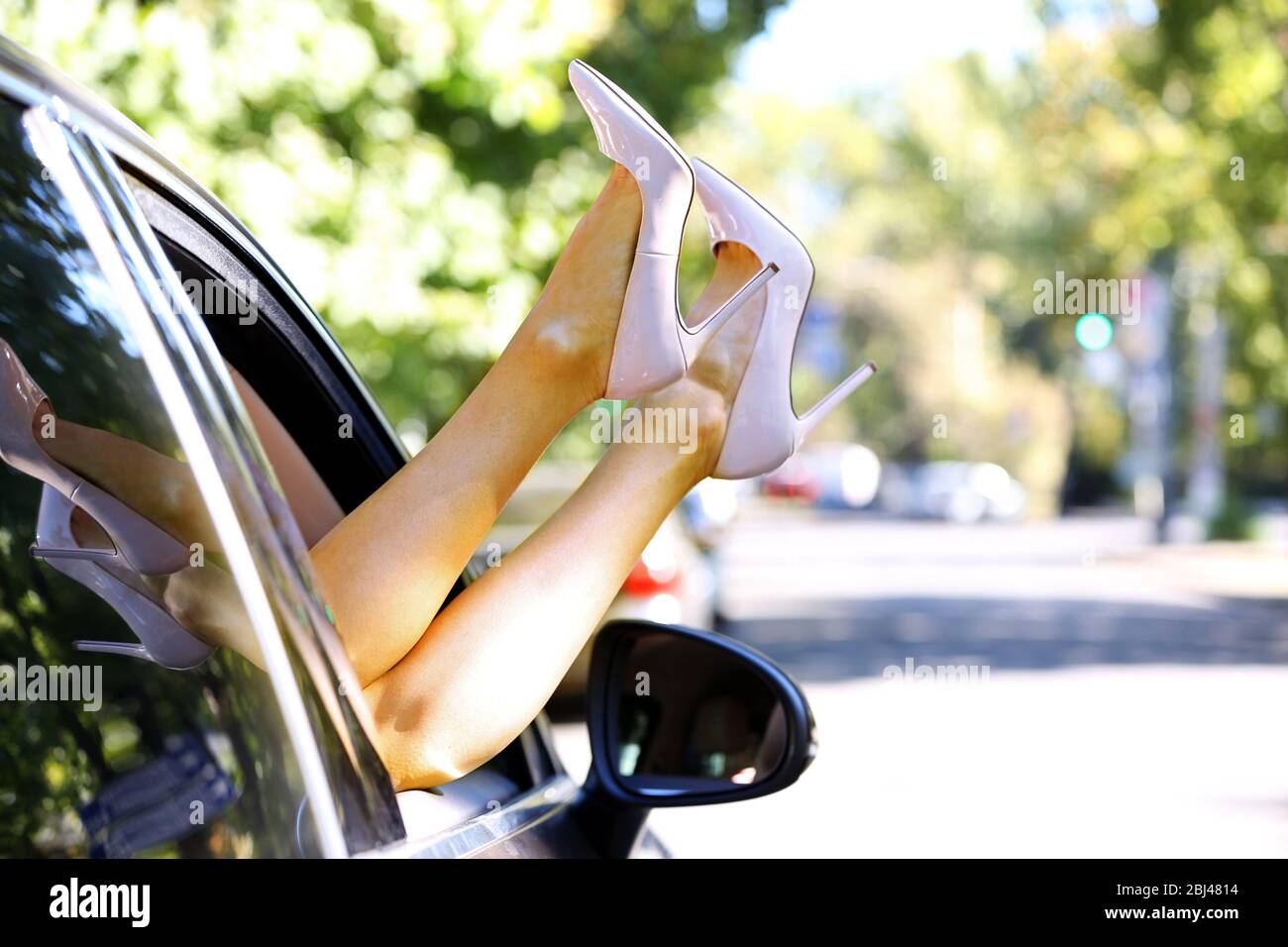 Woman's legs out of the car window Stock Photo - Alamy