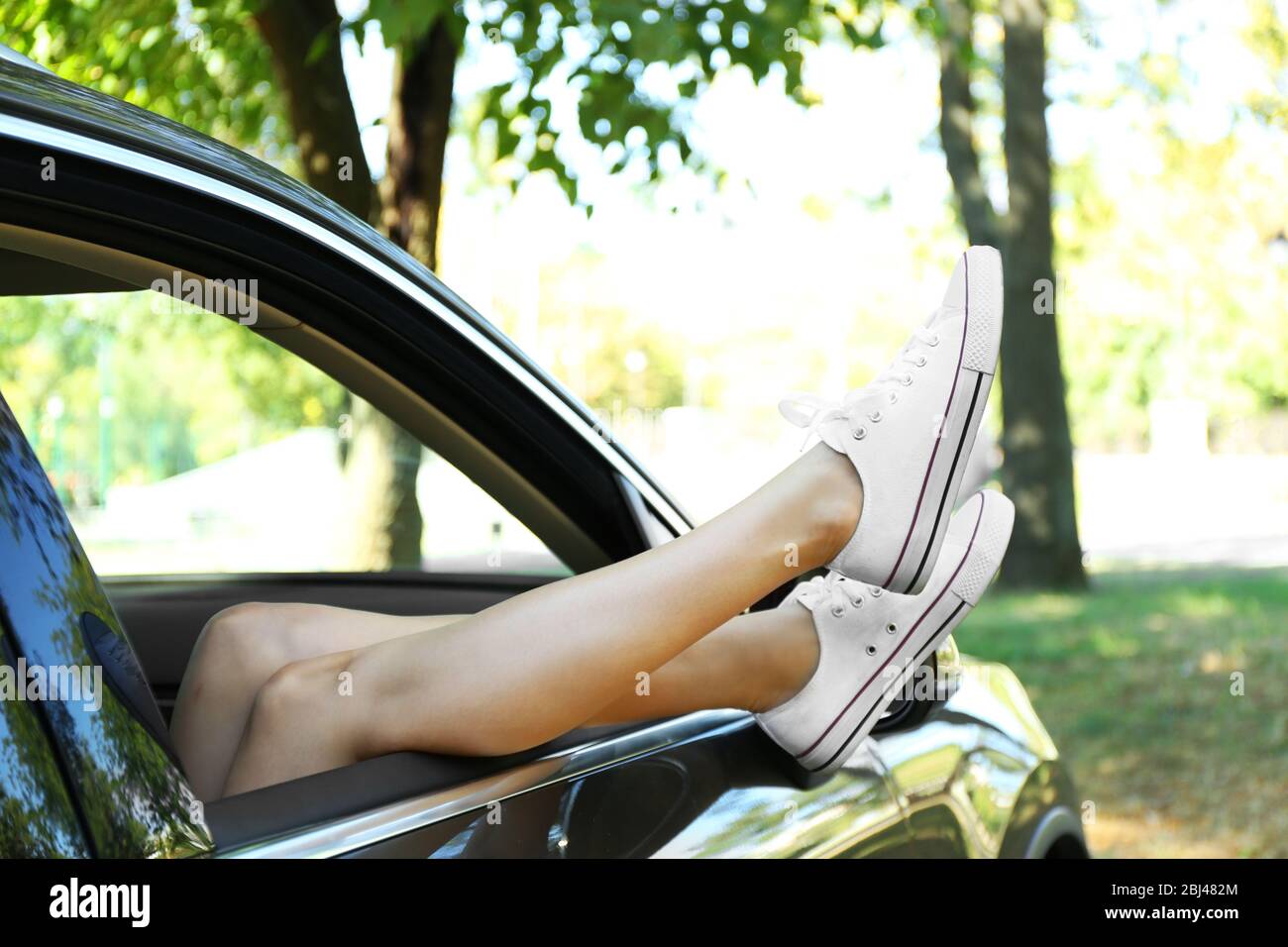 Woman's legs out of the car window Stock Photo - Alamy