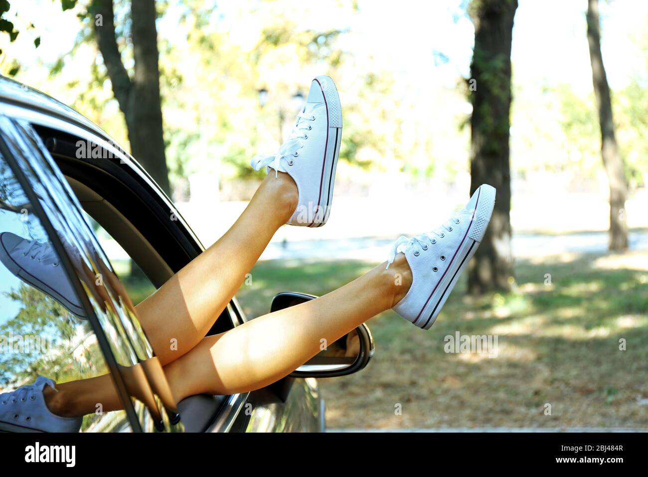 Woman's legs out of the car window Stock Photo - Alamy