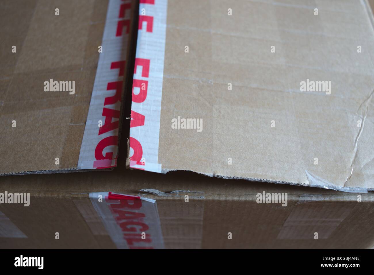 Cardboard box packaging with Fragile warning tape Stock Photo - Alamy