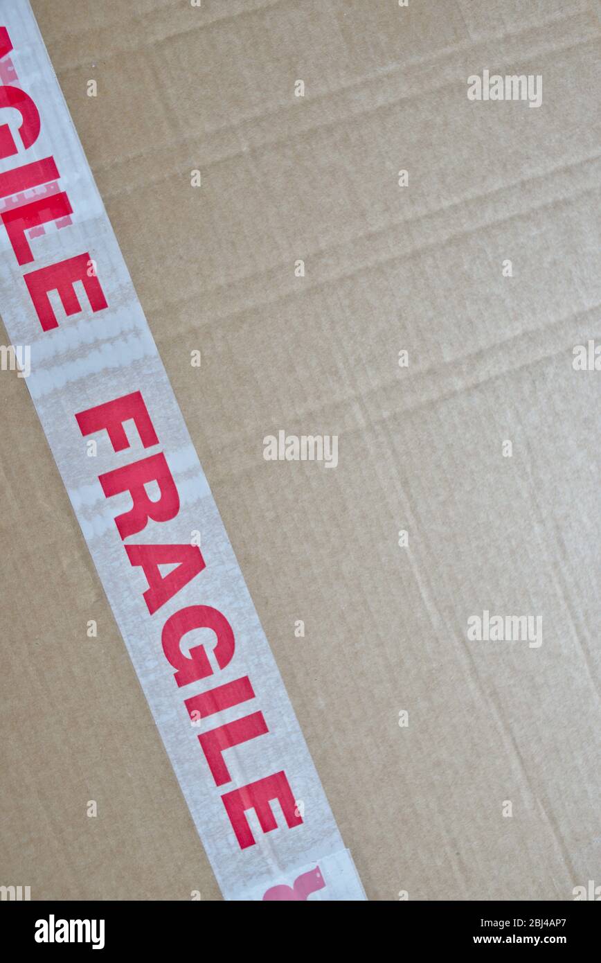 Cardboard box packaging with Fragile warning tape Stock Photo - Alamy