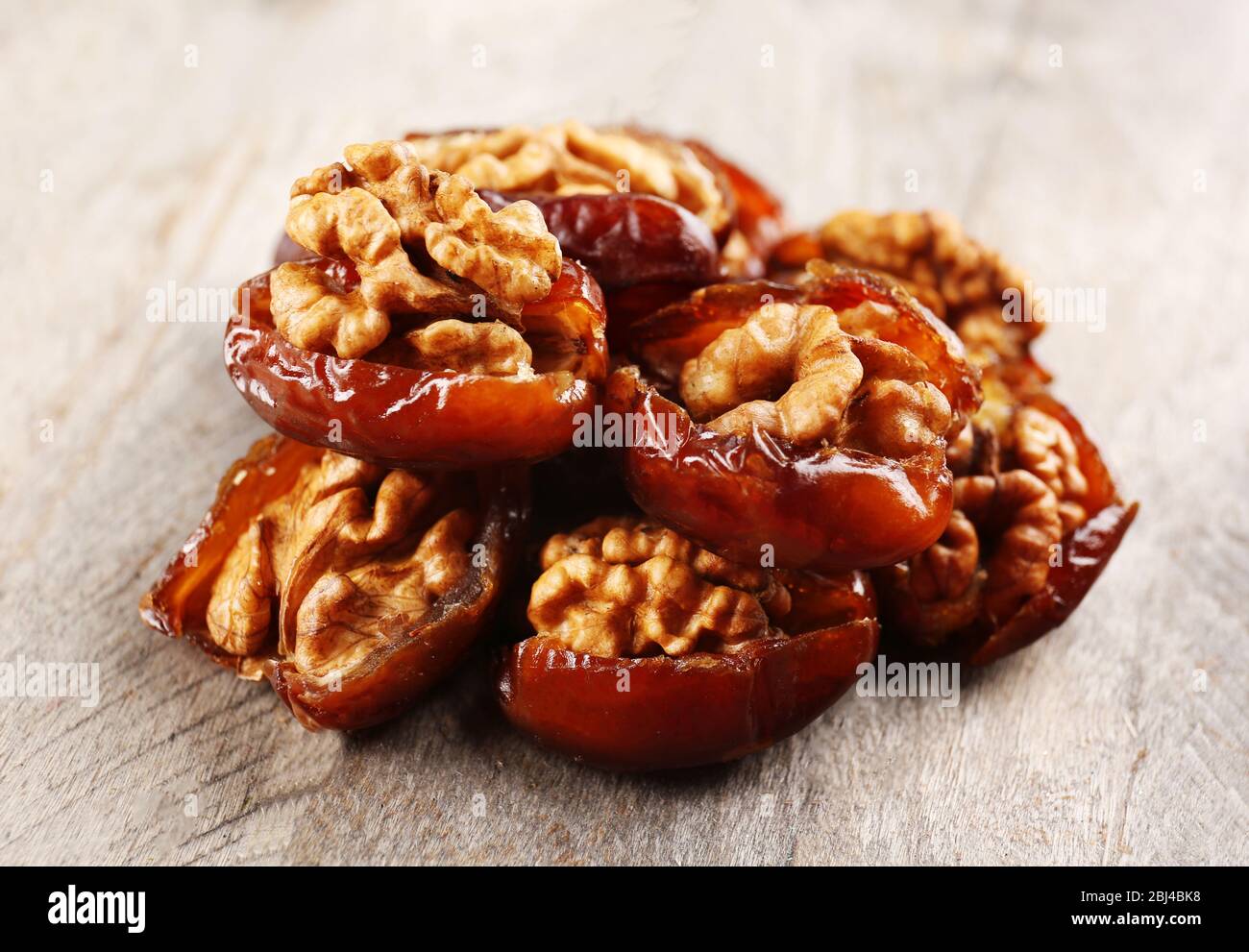 Walnut and date fruit on wooden table, close-up Stock Photo - Alamy