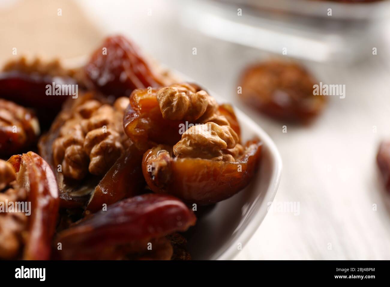 Walnut and date fruit on wooden table, close-up Stock Photo - Alamy