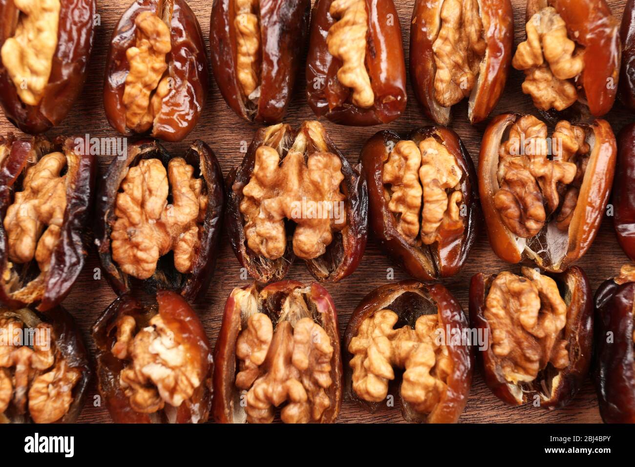 Walnut in date fruit on wooden table, close-up Stock Photo - Alamy