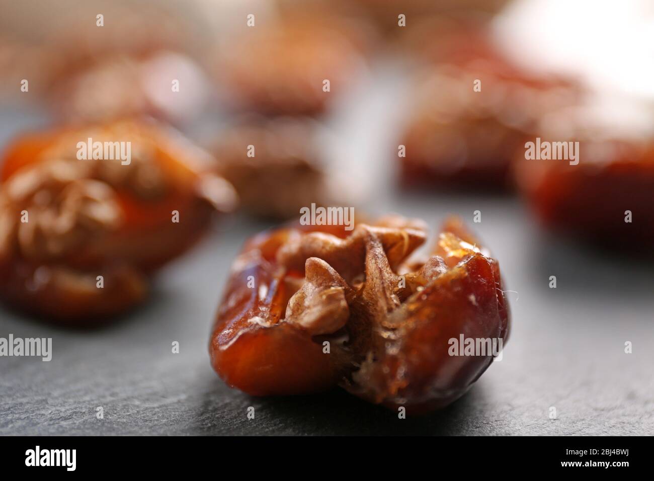 Walnut and date fruit on wooden table, close-up Stock Photo - Alamy