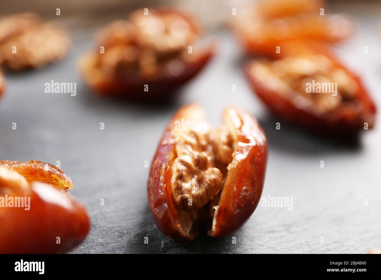 Walnut and date fruit on wooden table, close-up Stock Photo - Alamy