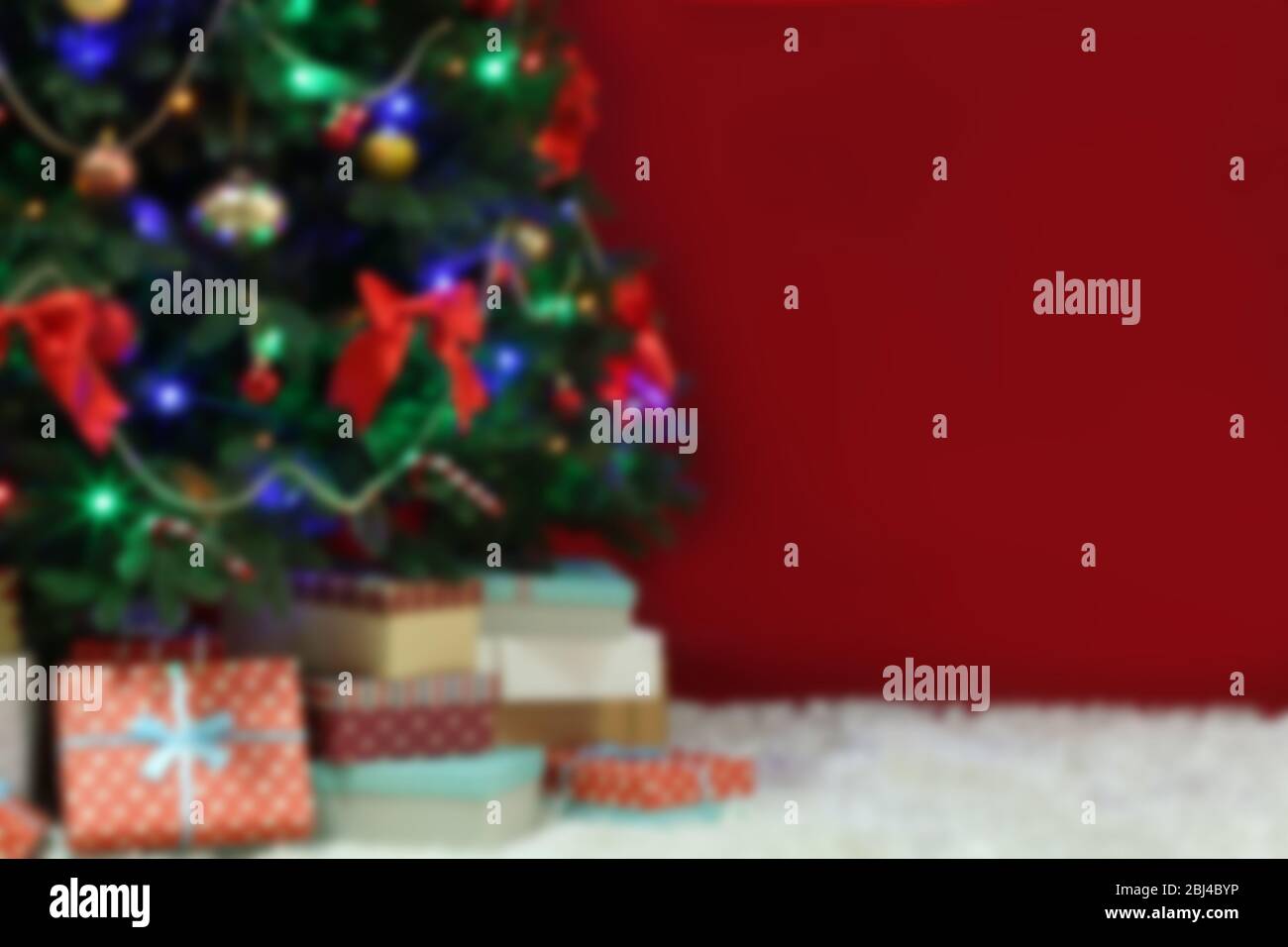 Decorated Christmas tree on red background Stock Photo - Alamy