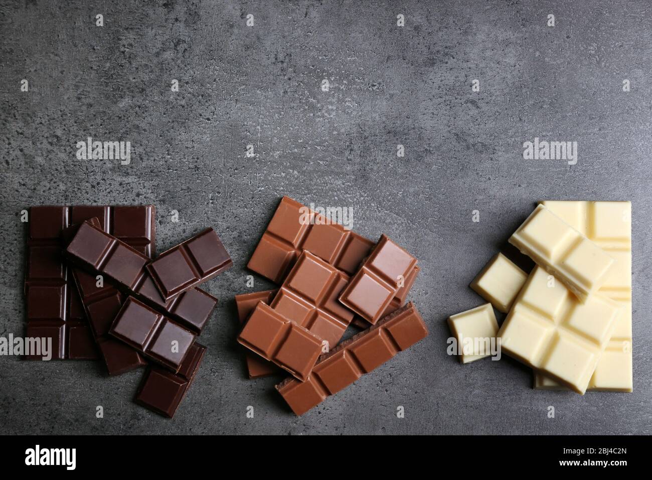 Different chocolate pieces on gray background Stock Photo - Alamy