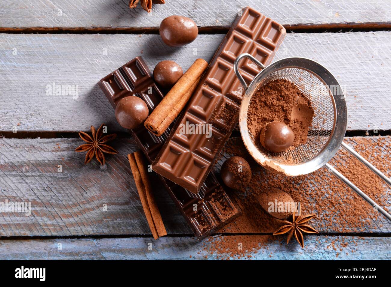 Chocolate sweets with powder on wooden background Stock Photo - Alamy