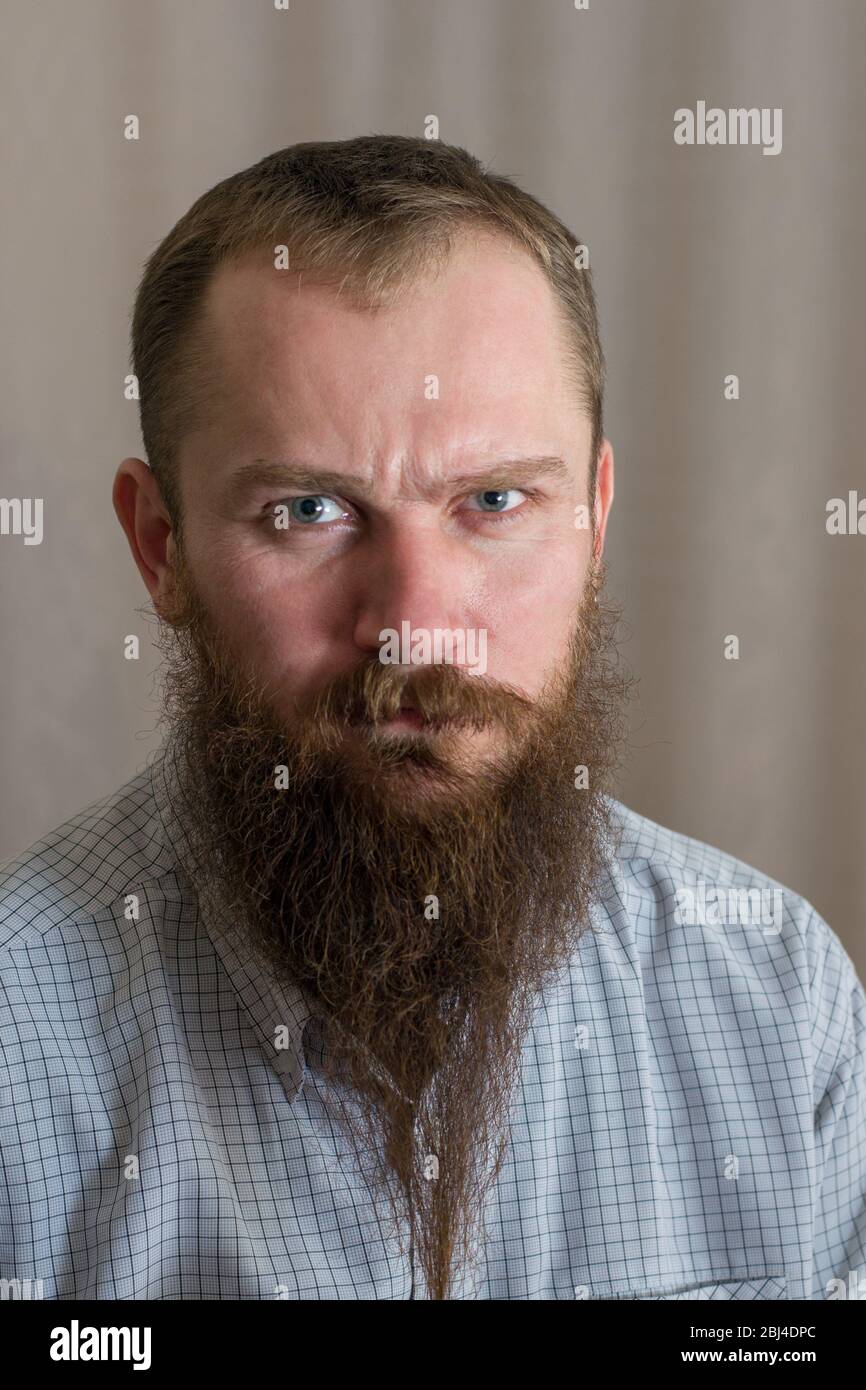 Portrait of a white serious angry man with a long beard Stock Photo - Alamy