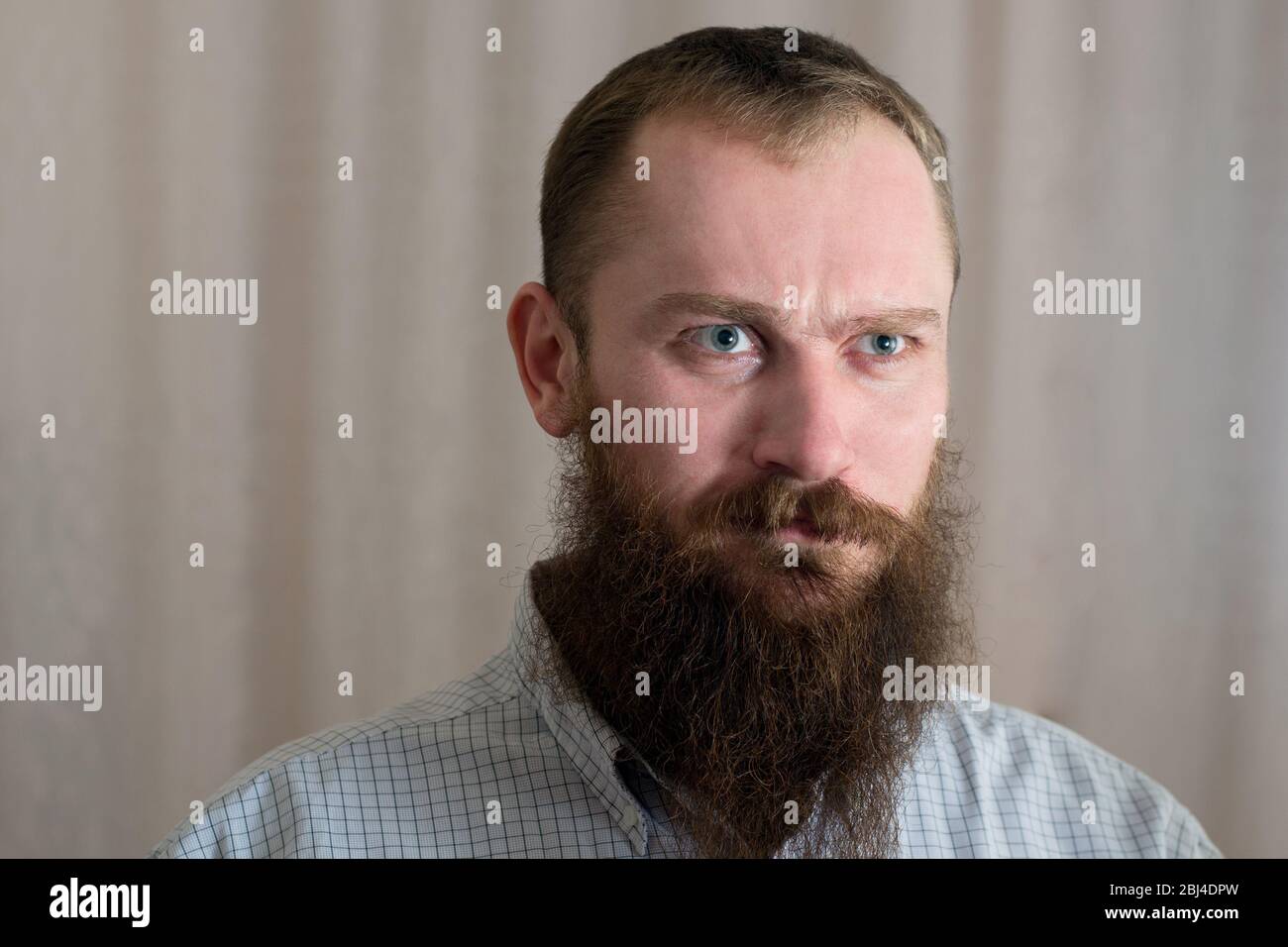 Portrait of a white serious angry man with a long beard Stock Photo - Alamy