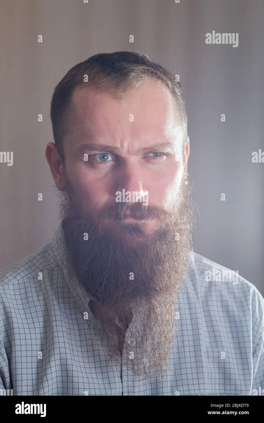 Portrait of a white serious angry man with a long beard Stock Photo - Alamy