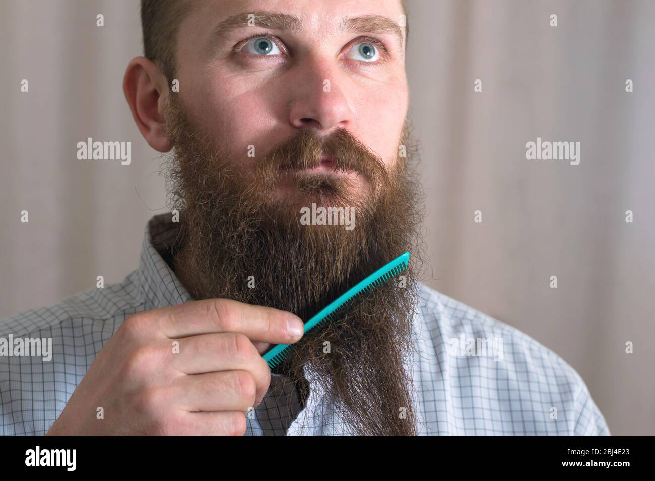 Photo of a man who combs his thick long beard Stock Photo - Alamy