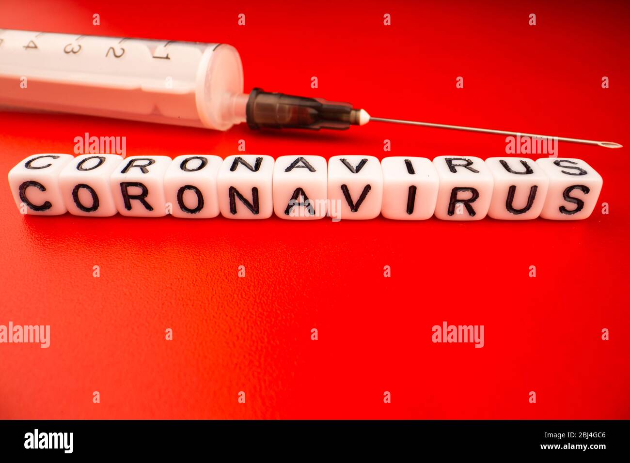Pandemic and virus concept - Coronavirus text with syringe on red ...