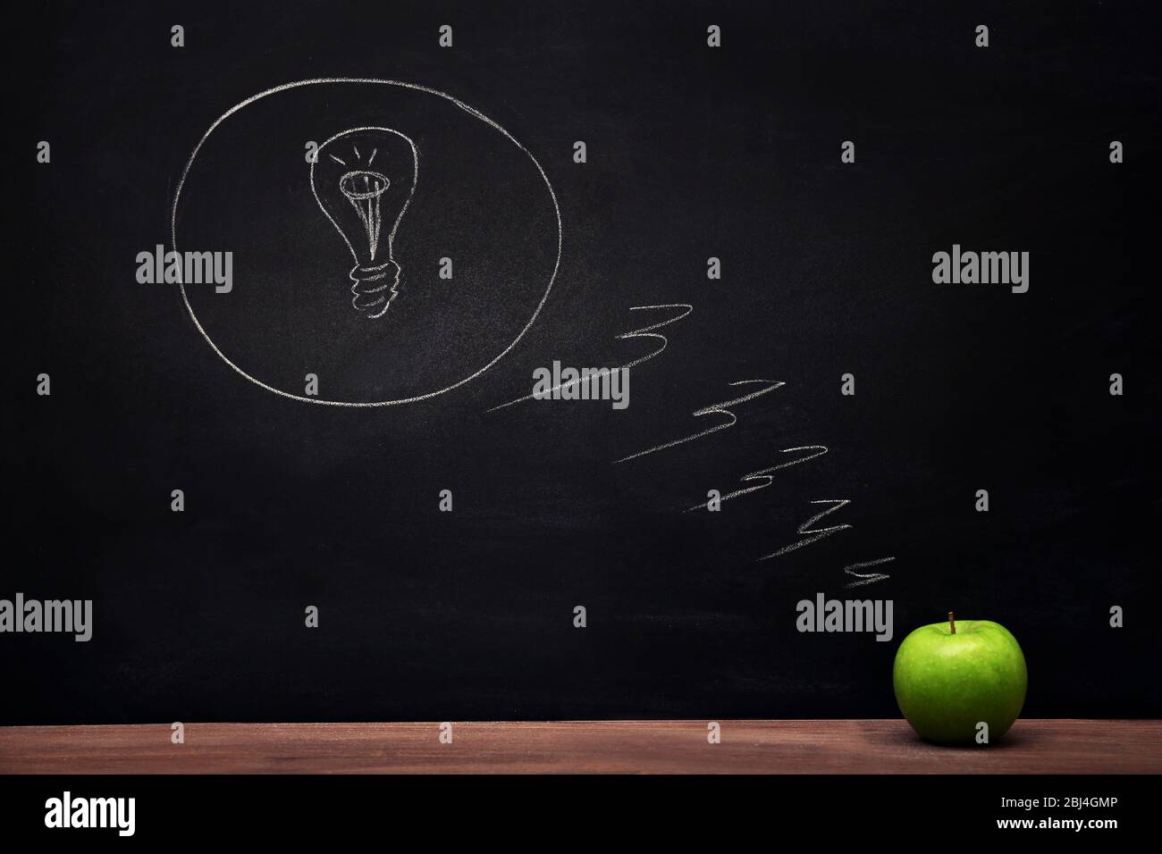 Apple on desk on blackboard background Stock Photo - Alamy
