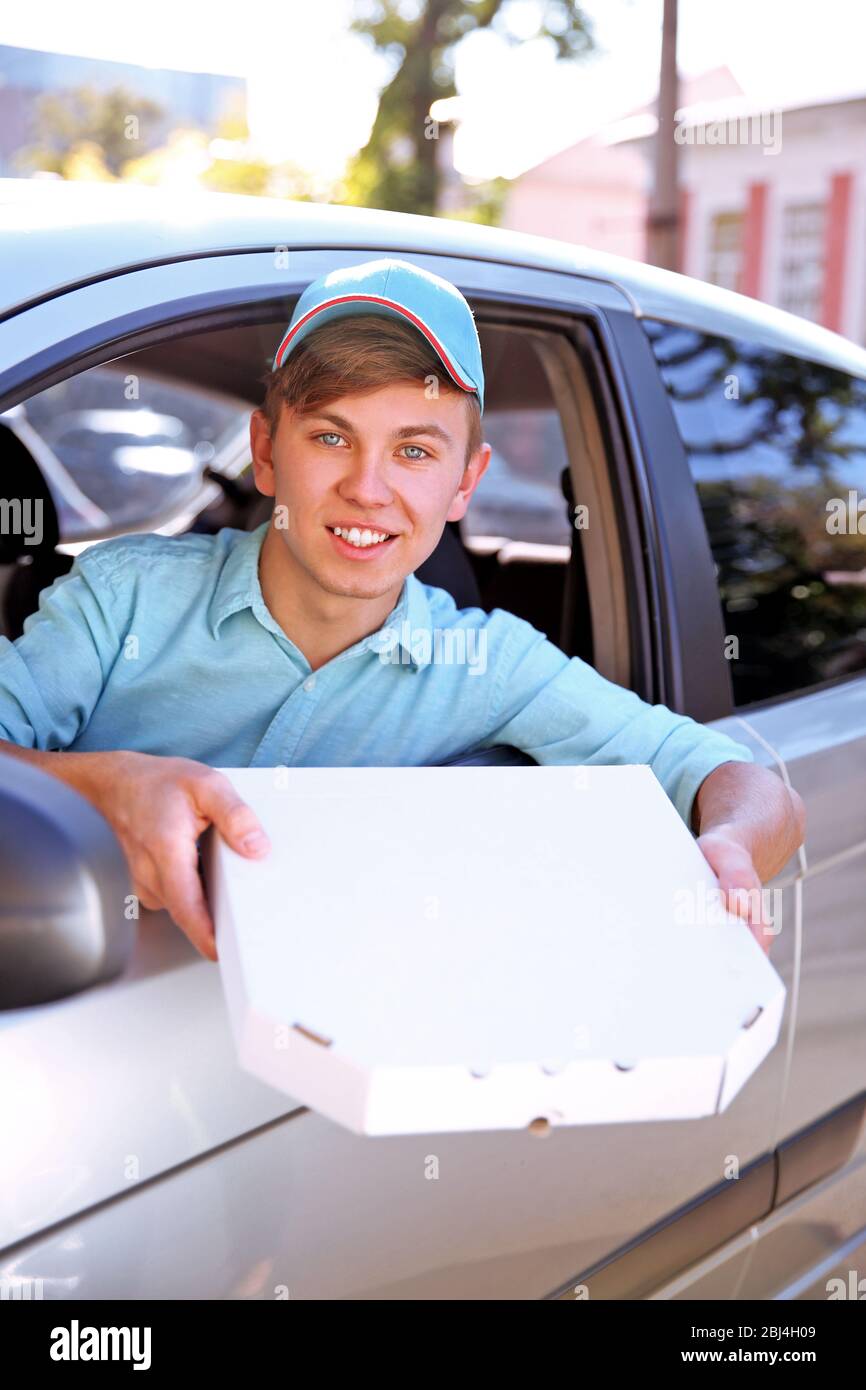 Pizza delivery boy in car, close-up Stock Photo - Alamy
