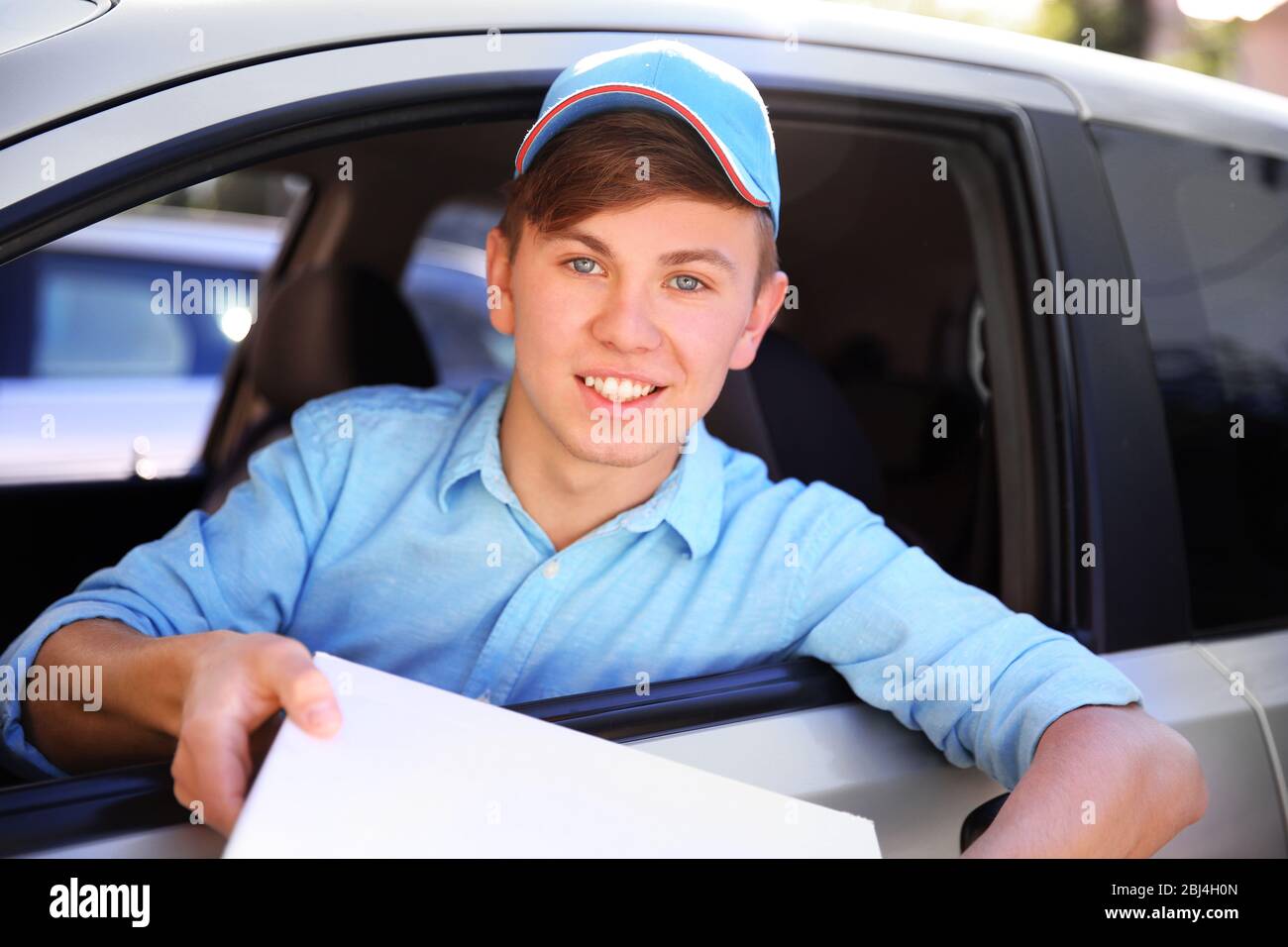 Pizza delivery boy in car, close-up Stock Photo - Alamy