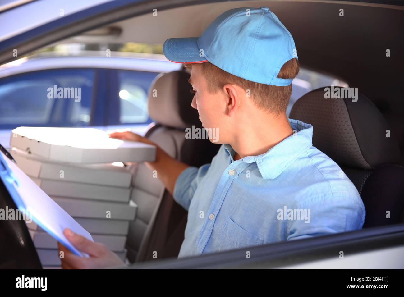 Pizza delivery boy in car, close-up Stock Photo - Alamy