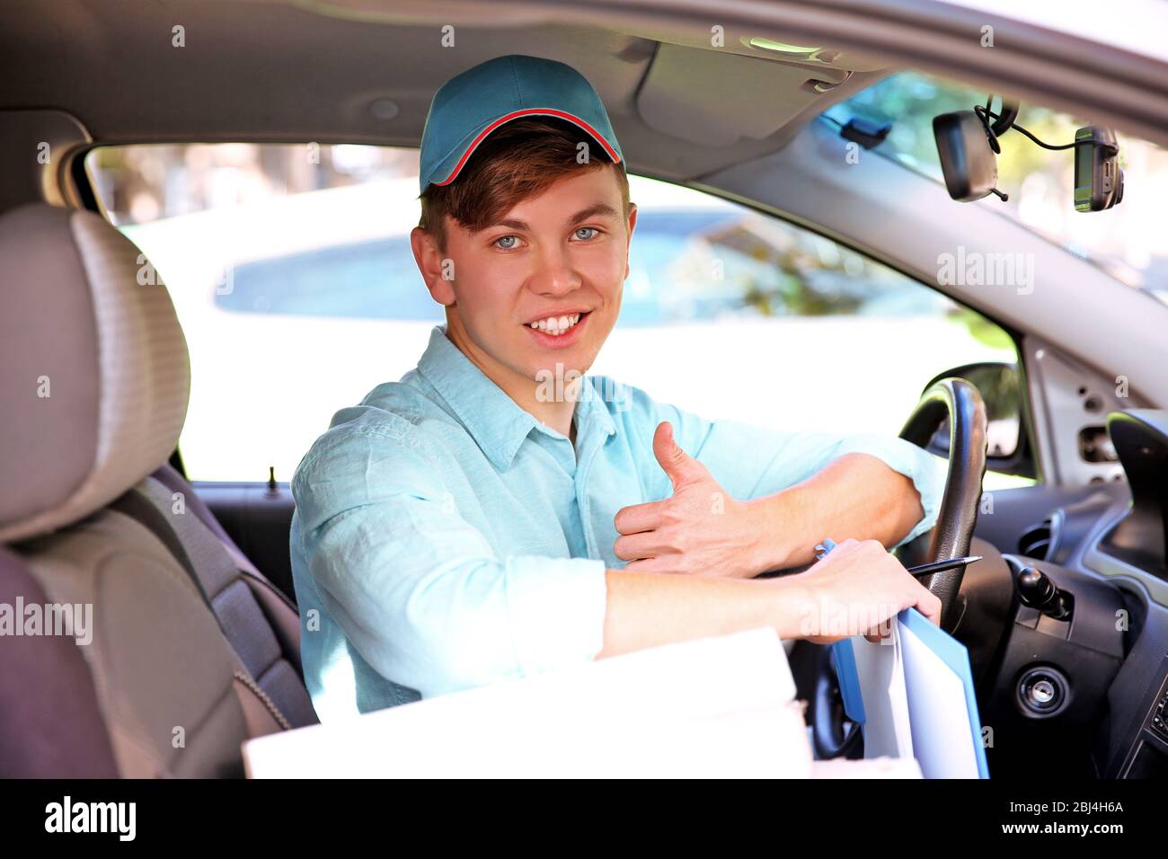 Pizza delivery boy in car, close-up Stock Photo - Alamy